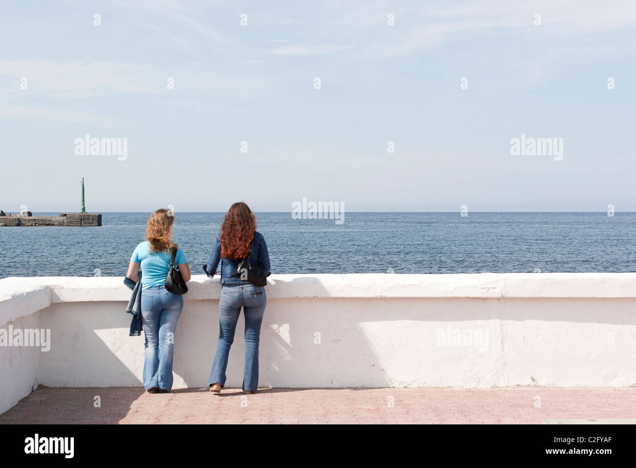 Women look out over the sea on the waterfront in Kholmsk, Sakhalin ...