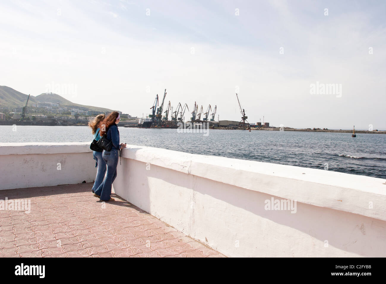 Women look out over the sea on the waterfront in Kholmsk, Sakhalin ...