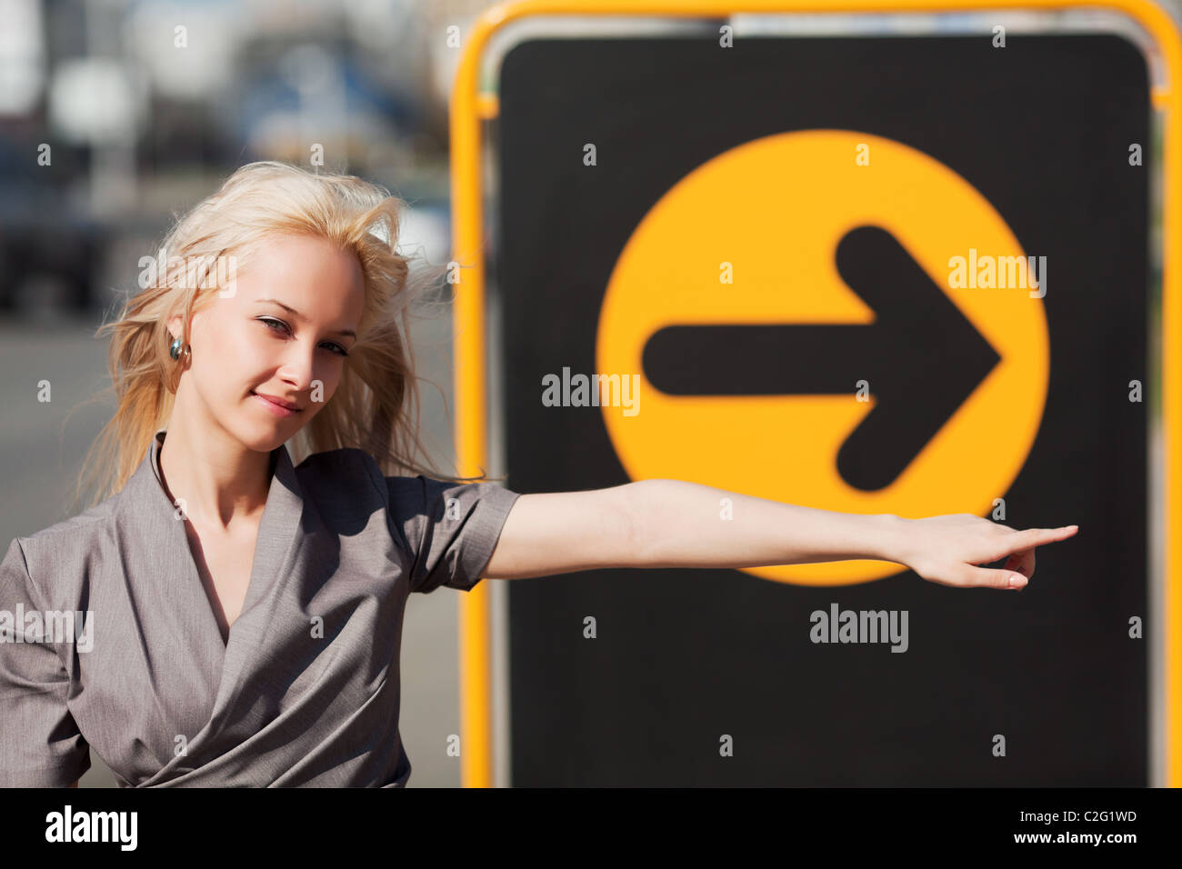 Young woman pointing a direction Stock Photo - Alamy