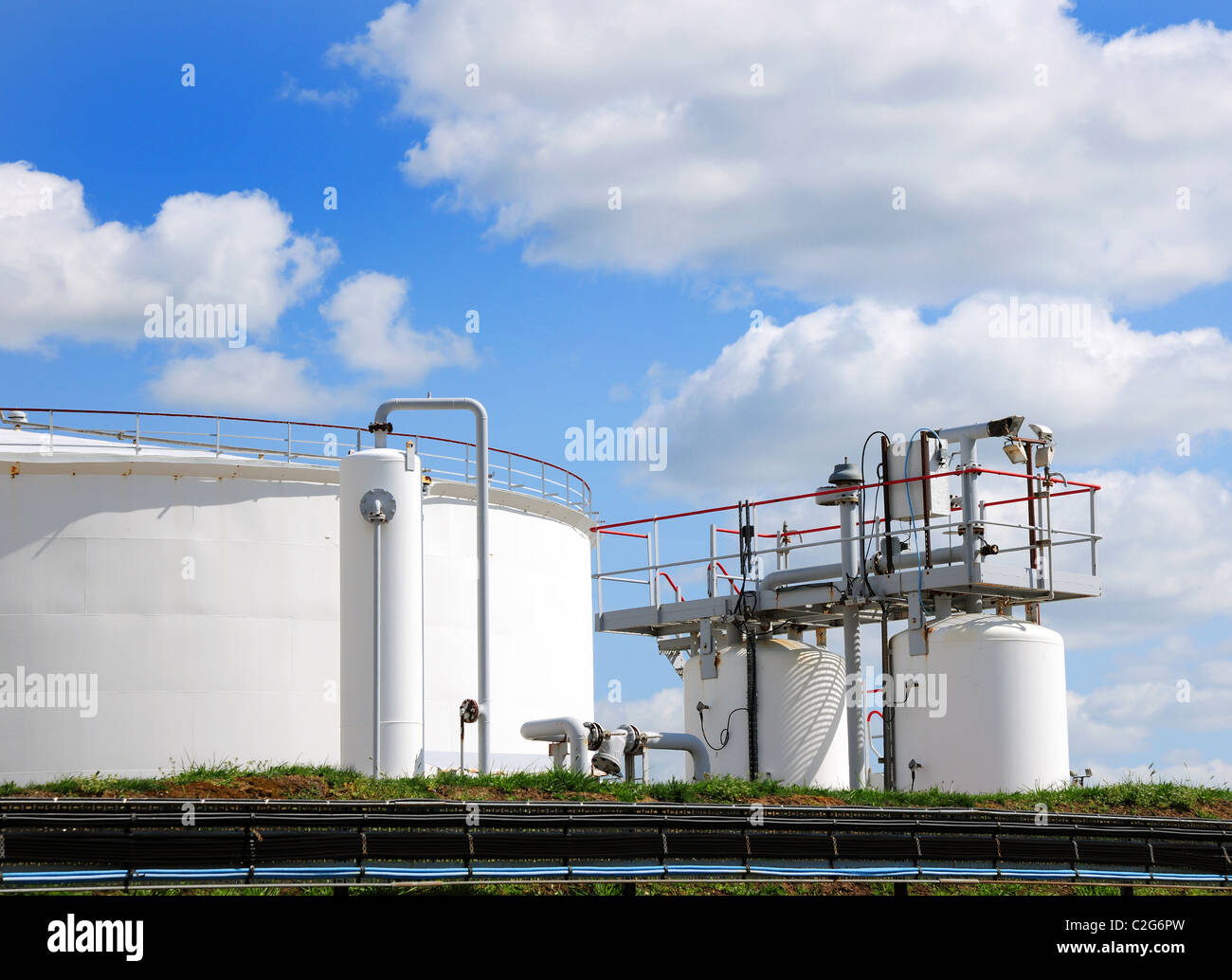 Detail of an oils storage facility with deep blue sky and brooding ...