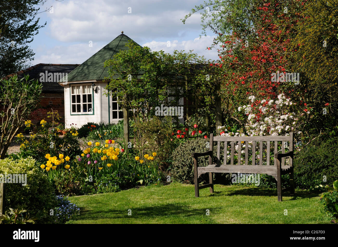 English country garden with Spring flowering plants a summer house ...