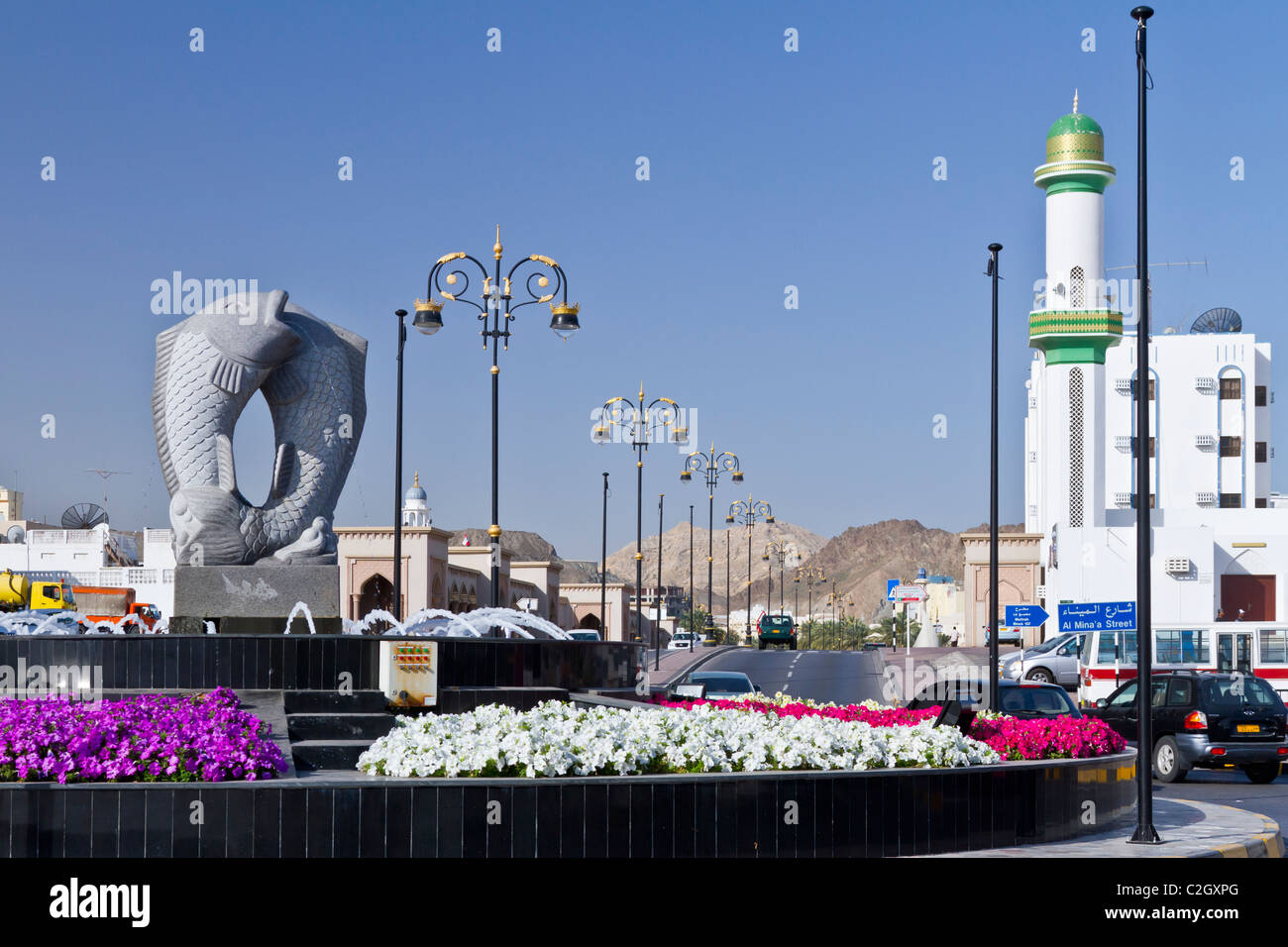 A mosque, street roundabout and fish sculptures in the city of Muscat ...