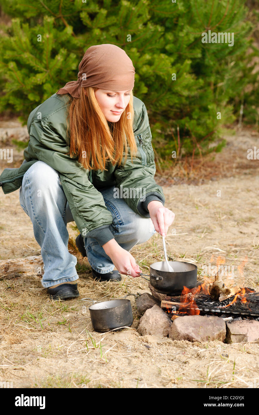 Camping happy woman cook food fire nature Stock Photo - Alamy