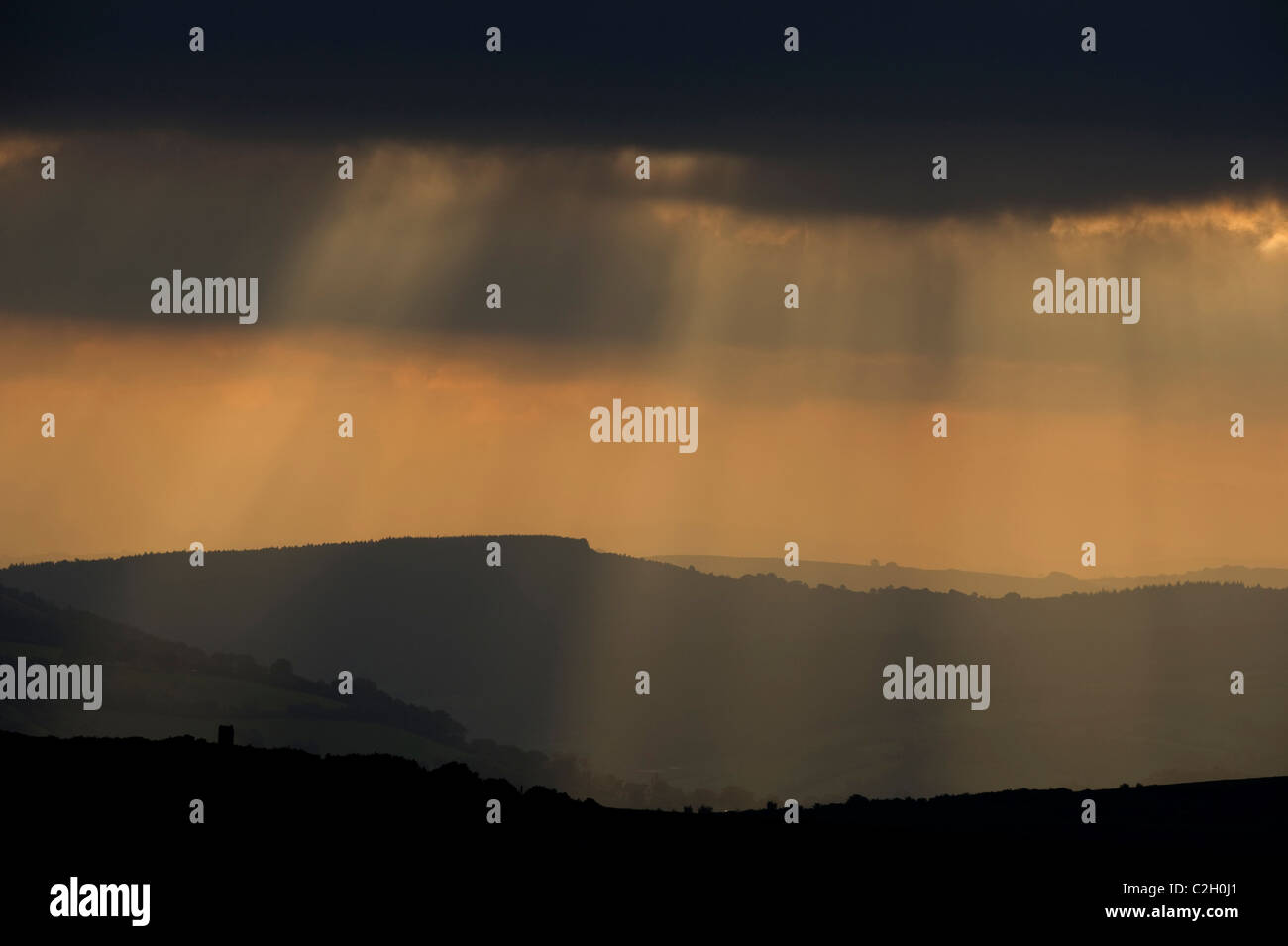 early morning sun rays break through the sky across Exmoor near Porlock ...