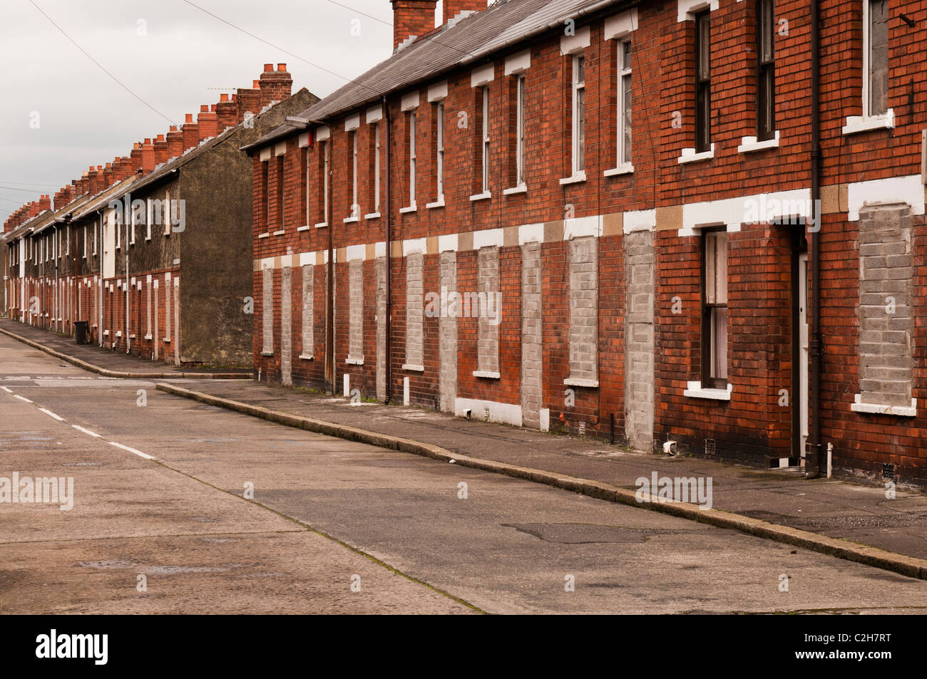 Bricked up and abandoned town houses in a run-down inner city street in ...