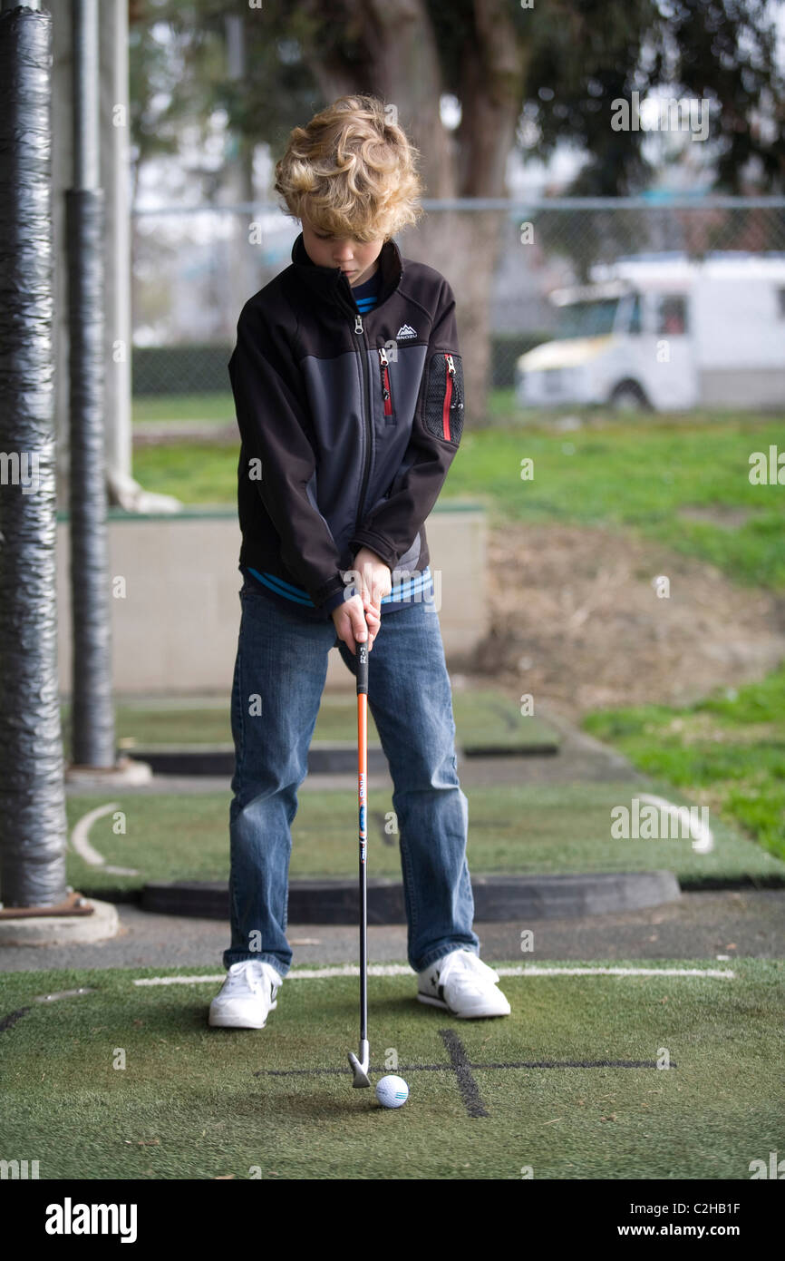 Young boy golfing Stock Photo - Alamy