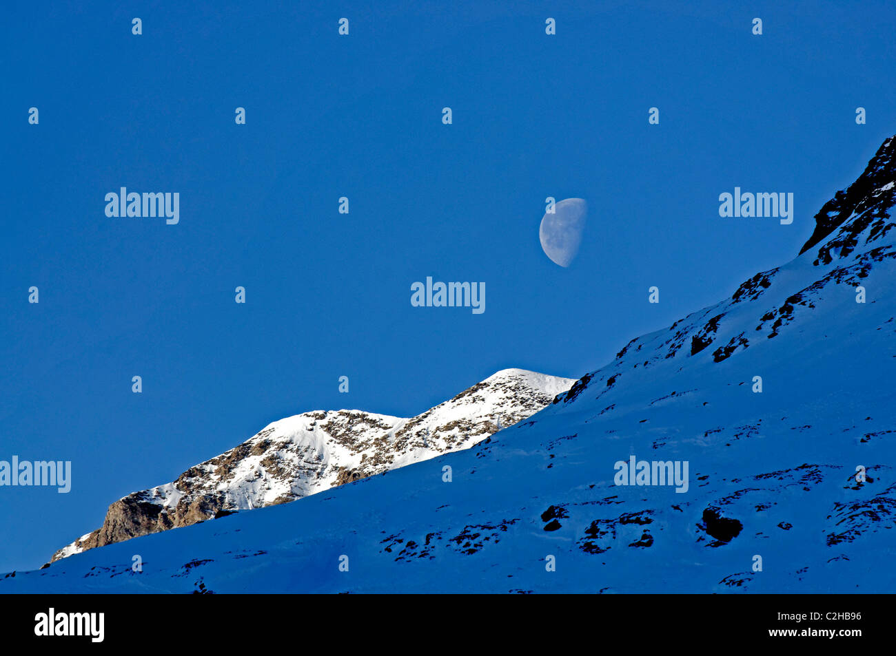 The moon high over an alpine peak in the Haute Maurienne, France Stock ...