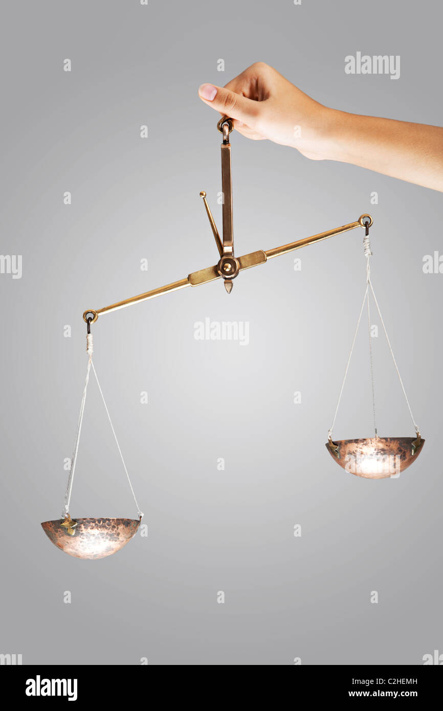 Hand of judge holding scales in isolation Stock Photo - Alamy