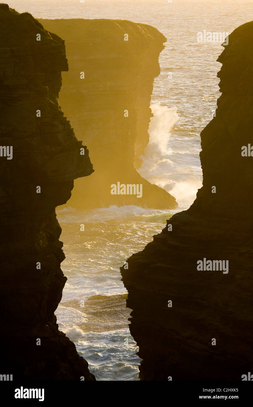 Sunset illuminates a chasm in the atlantic cliffs near Loop Head ...