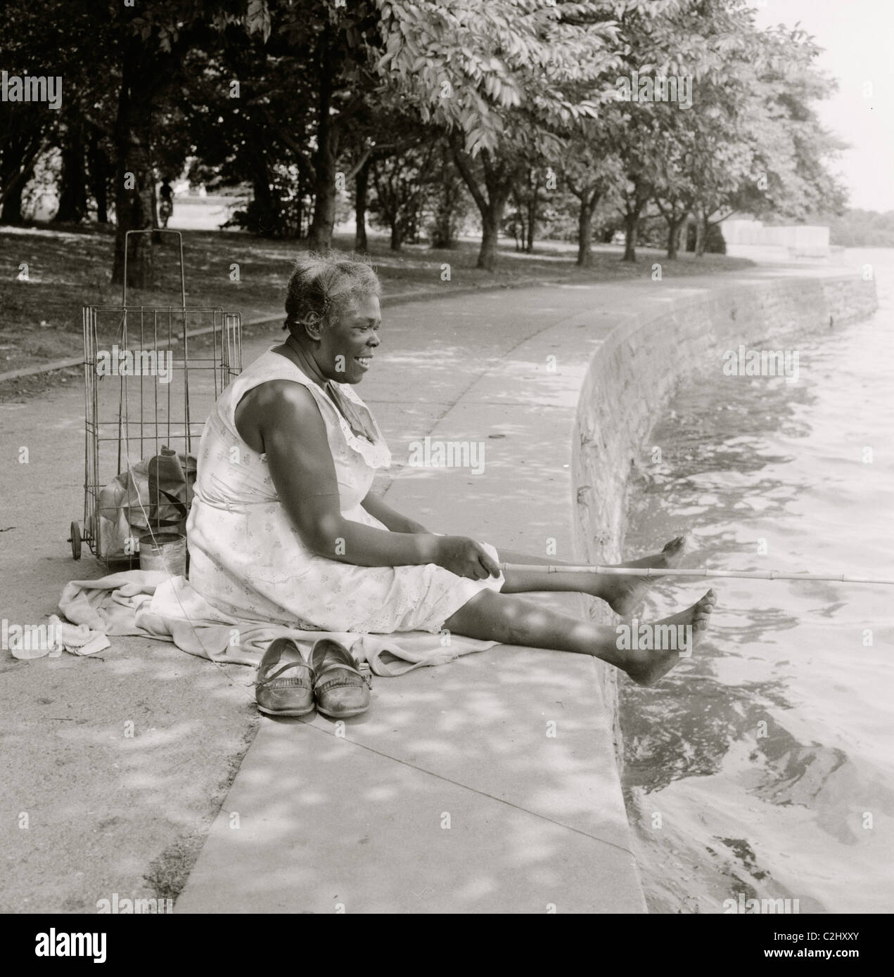 African American woman, seated on ground, fishing, at the Tidal Basin ...