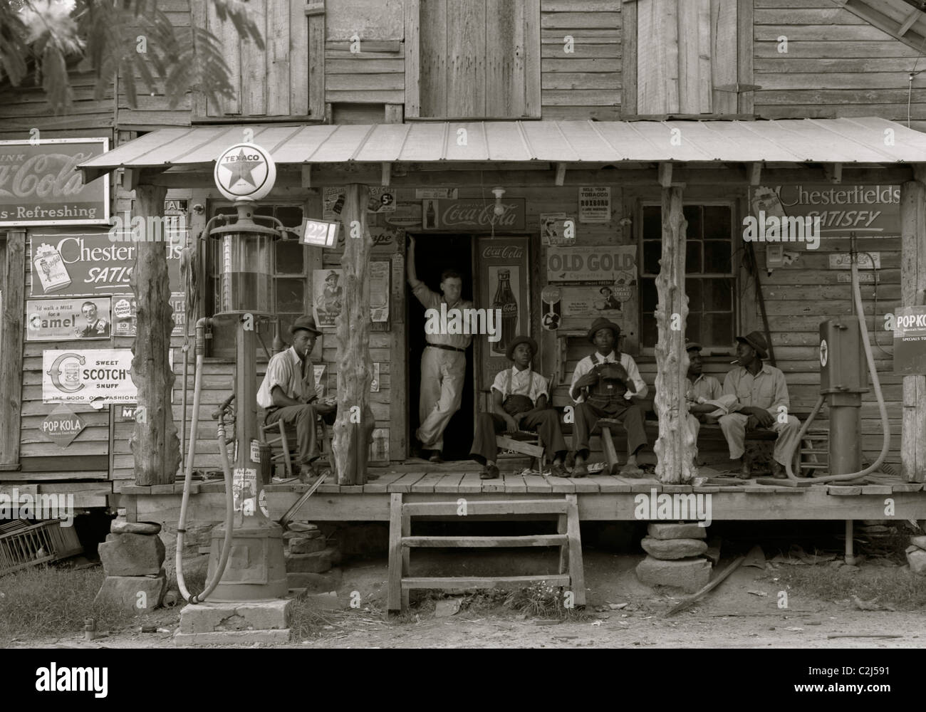 African American and a white store owner on the Porch of a country ...