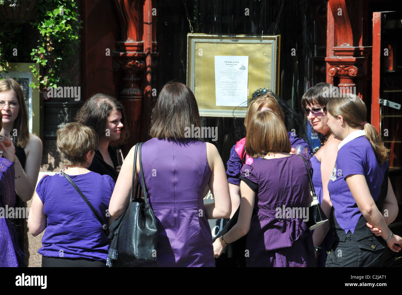 Ladies on a Hen night meeting for drinks outside a pub dressed in ...
