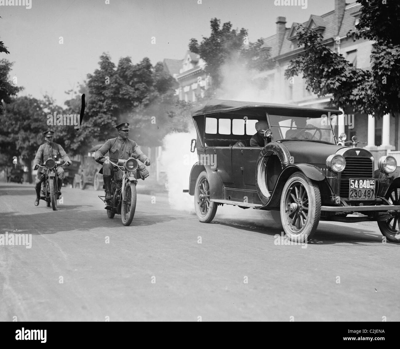 Police on motorcycles trailing car with smoke Stock Photo - Alamy