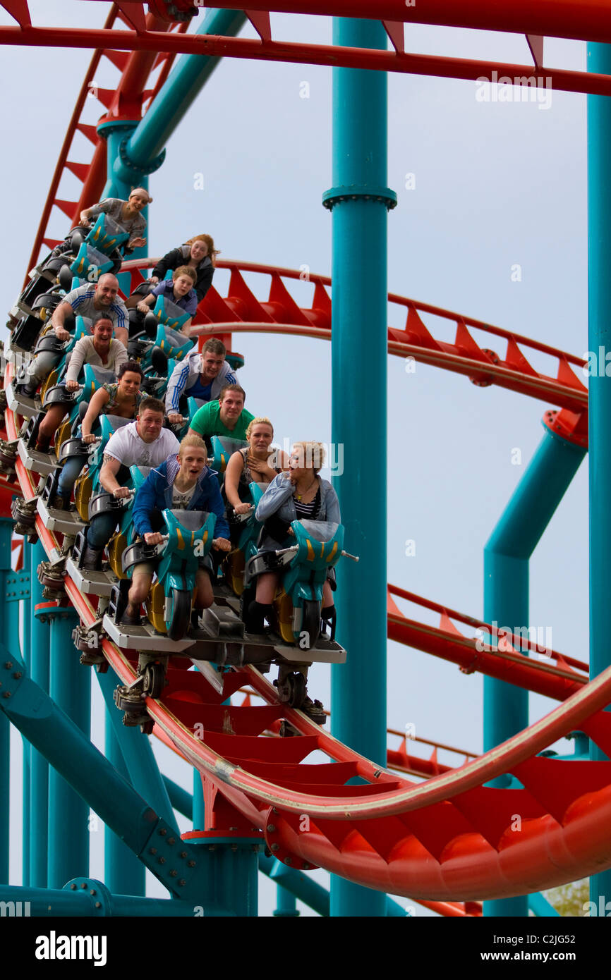 Riders enjoying exhilarating Roller Coaster, White knuckle Fairground ...