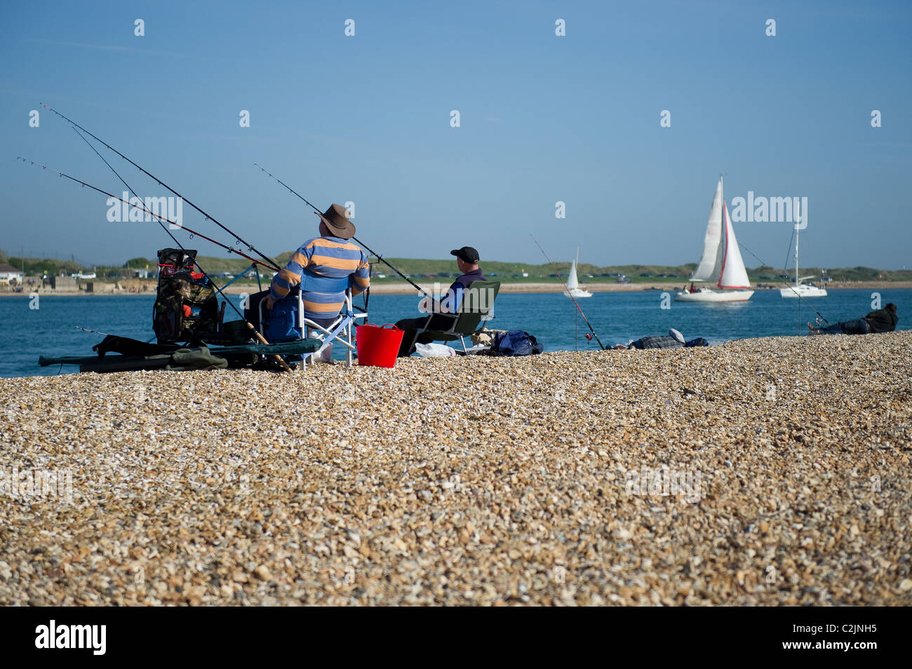 two fishermen on the beach at Langstone Harbour in Portsmouth on a ...
