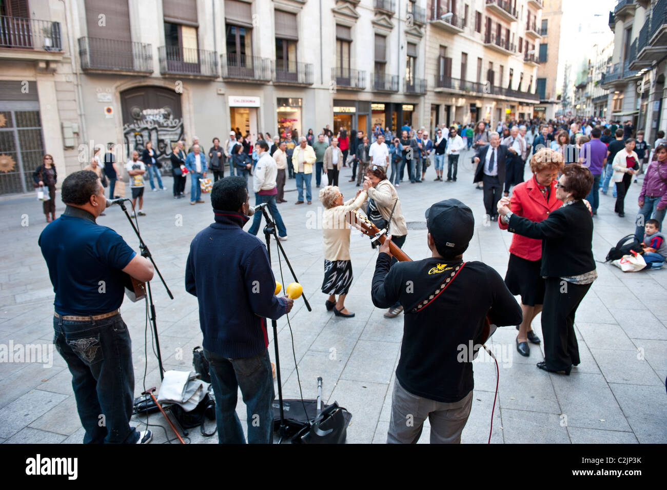 Musicians performing in the streets of Barcelona with people dancing ...