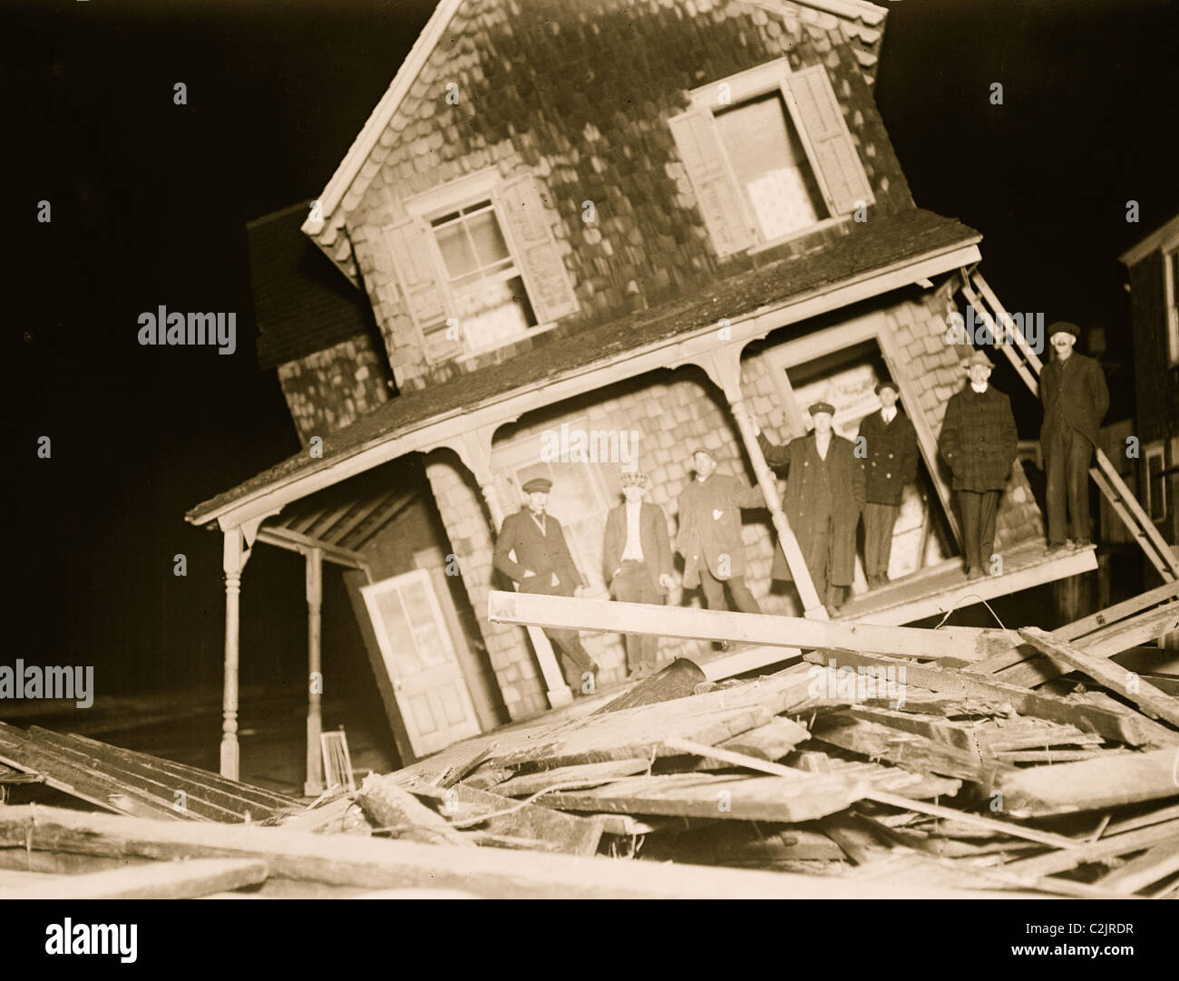 Wrecked Cottage at Seabright with men on tilted front Porch Stock Photo ...