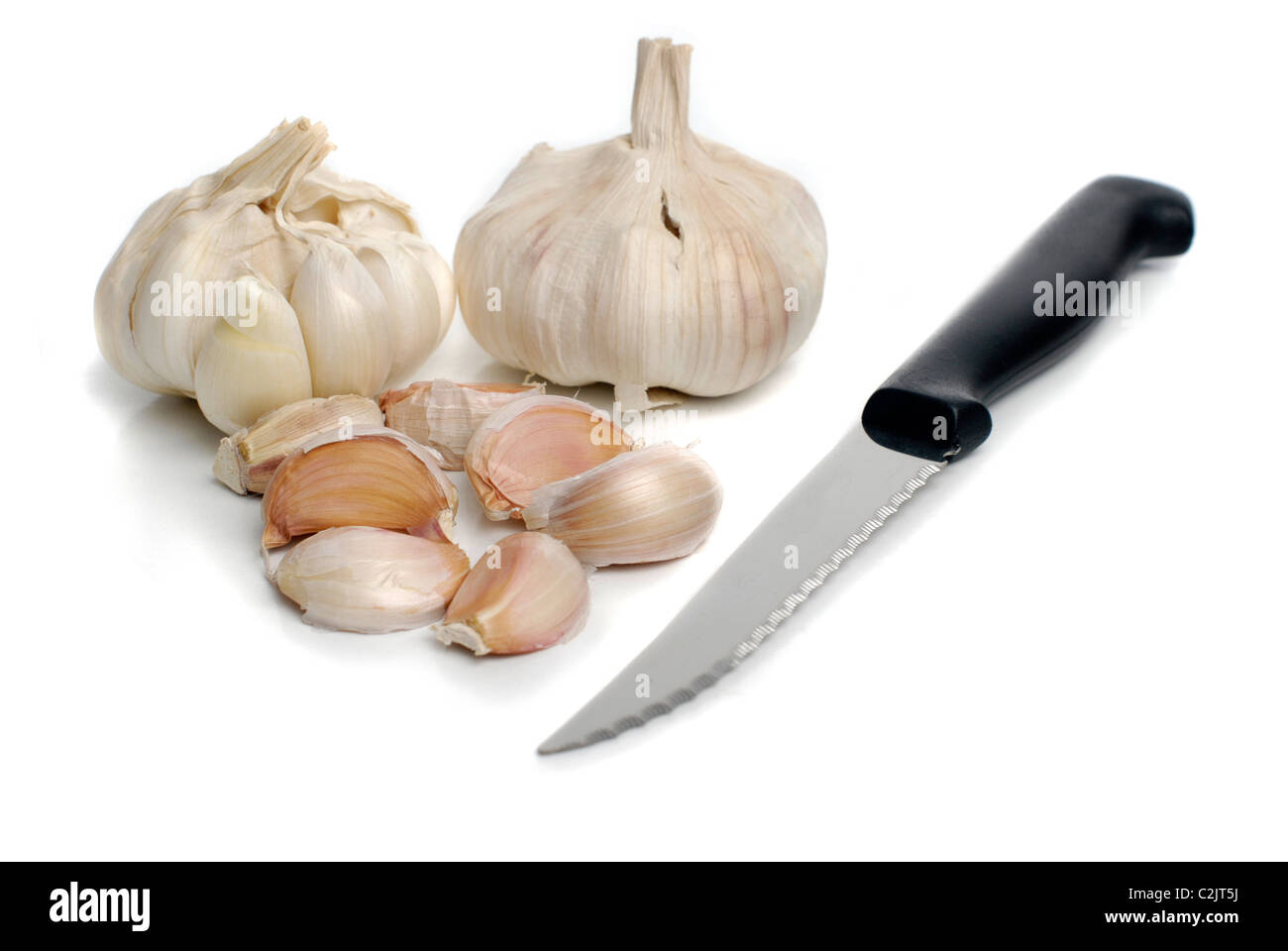 Two garlic and kitchen knife on white background with shadow reflection ...