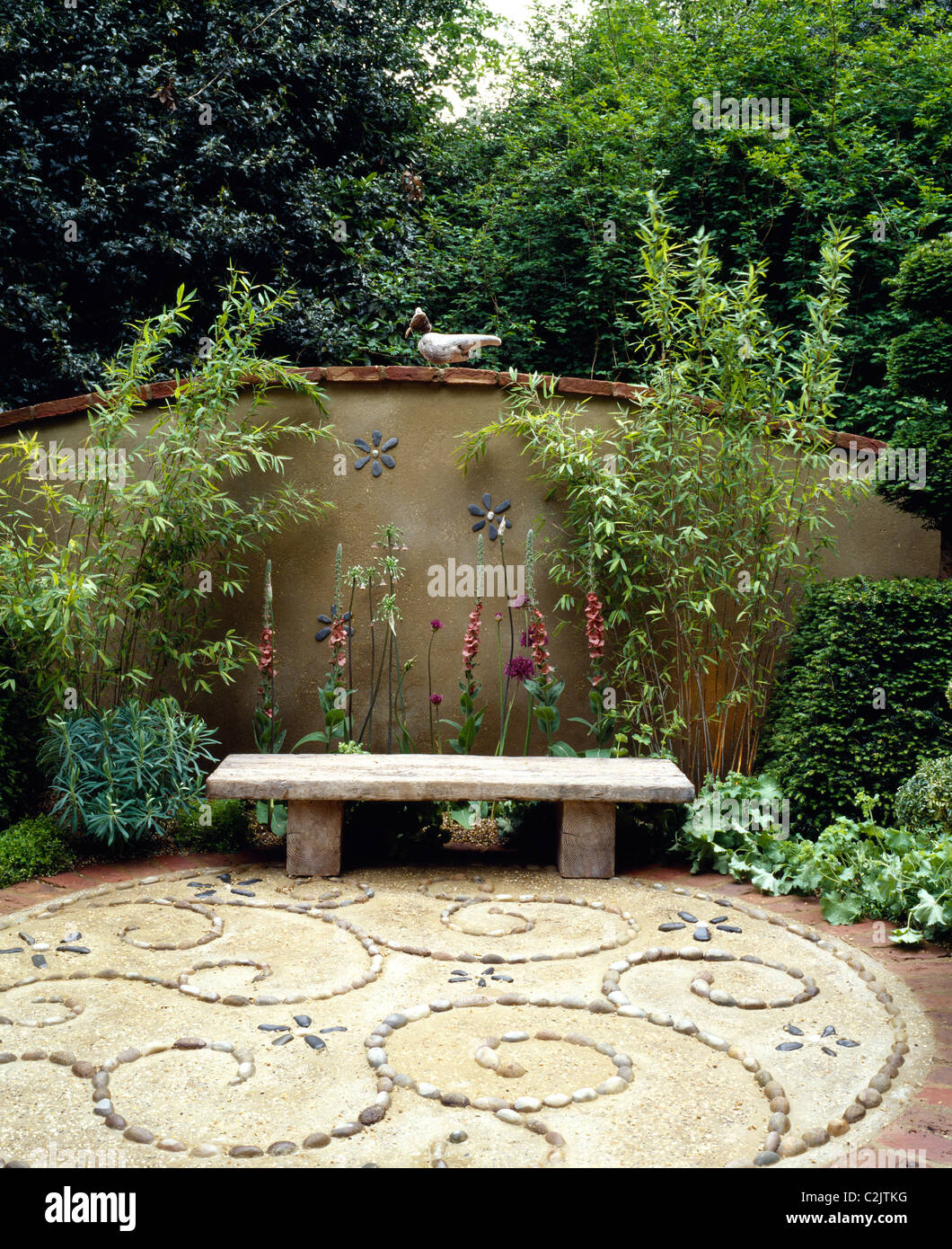 Courtyard garden with circular pebble motif on floor Stock Photo - Alamy