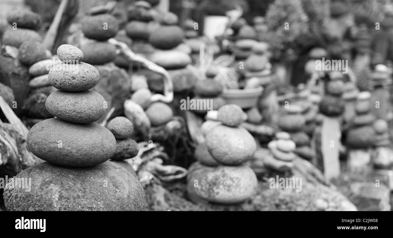 Funny little piles of round rocks with soft focus background in black ...