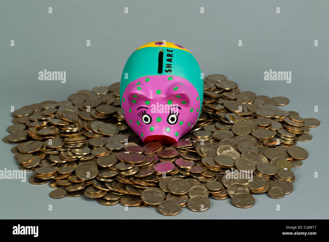 A colorful piggy bank overflows with coins Stock Photo - Alamy