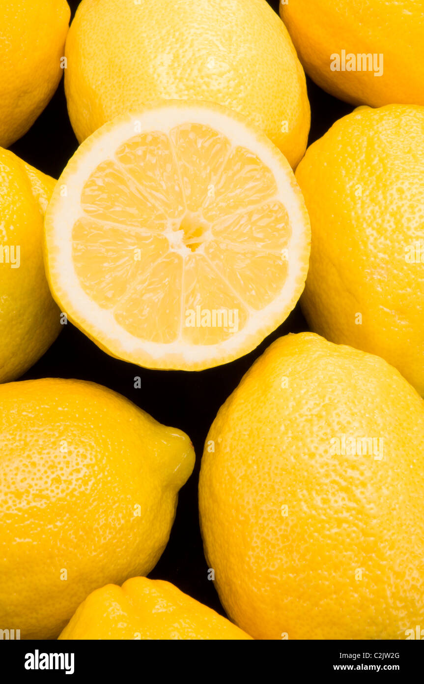 Lemons and sliced lemon on black Stock Photo - Alamy