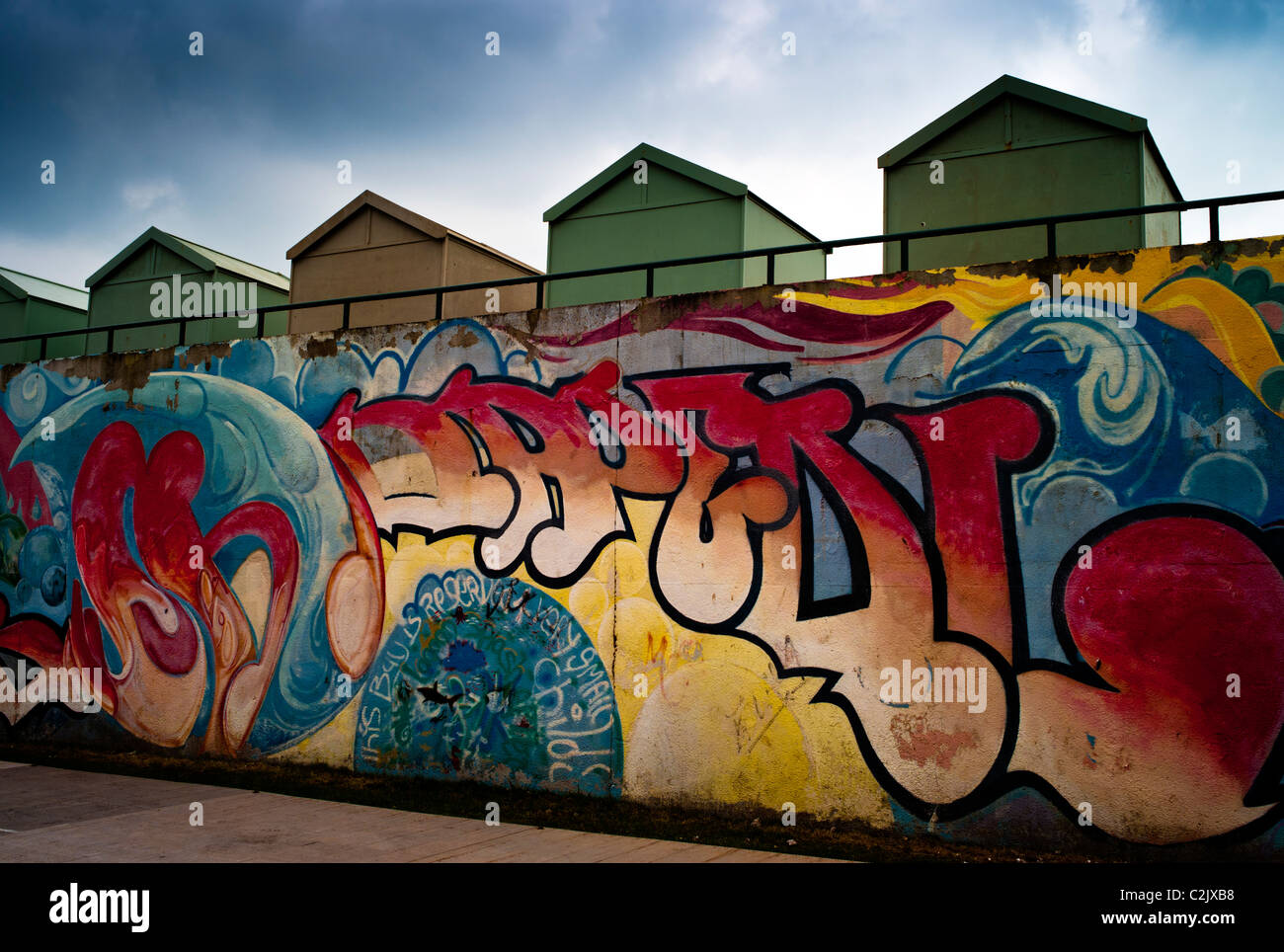 Colourful graffiti on a wall in front of beach huts at Hove (near ...