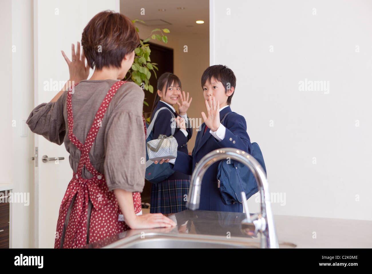 Mother Seeing Off Children at Kitchen Stock Photo - Alamy