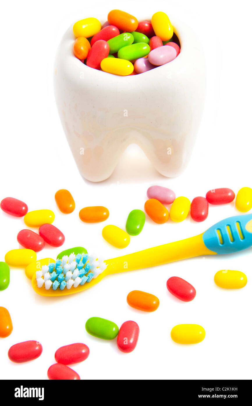 Molar filled with candy with tooth brush in front isolated over white ...