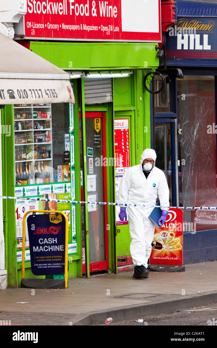 Police forensic officers investigate the Stockwell Food & Wine shop ...