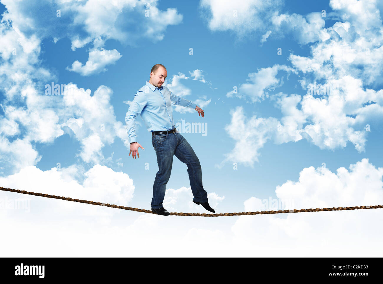 man walk on rope with blue sky background Stock Photo - Alamy