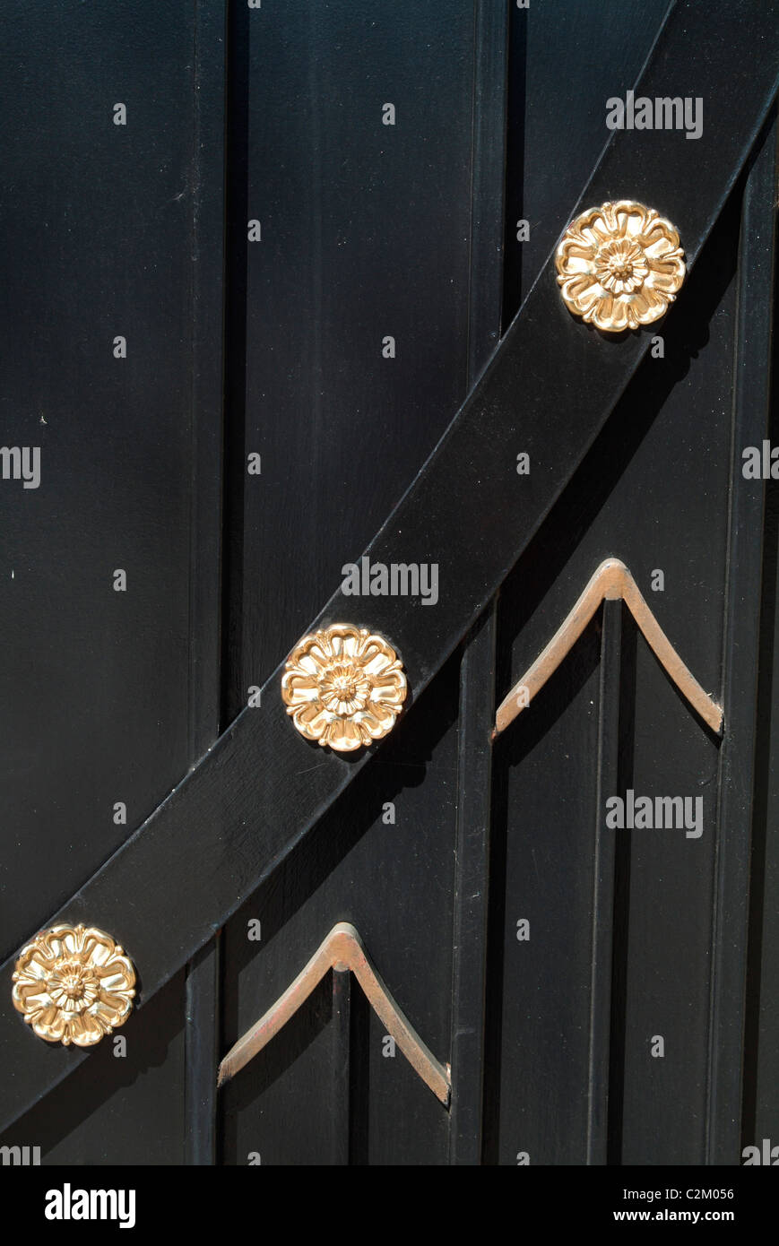 Backgrounds - detail of black stained wooden gate decorated with gold ...