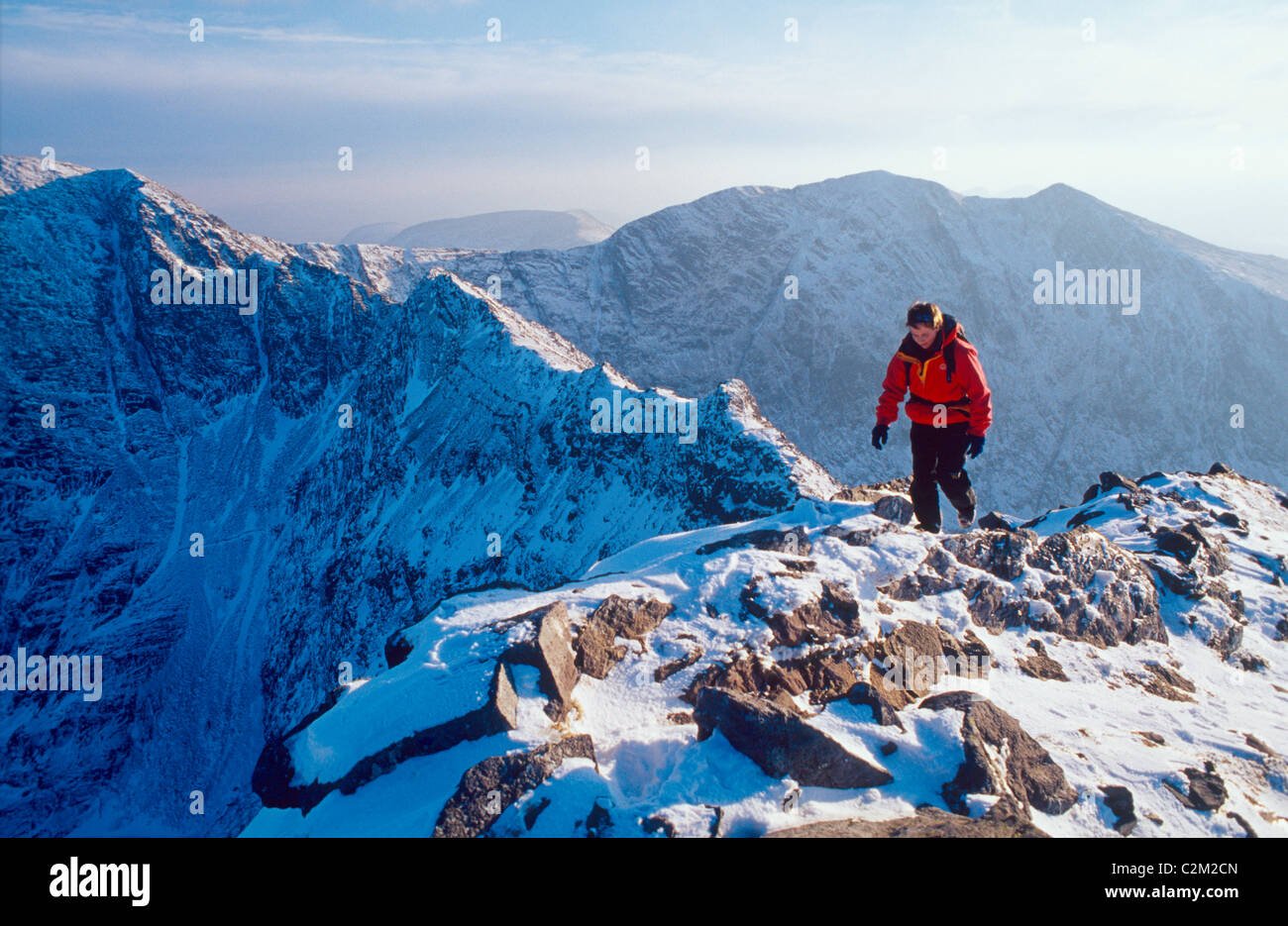 Winter walker on the Beenkeragh Ridge, with Carrauntoohil behind ...
