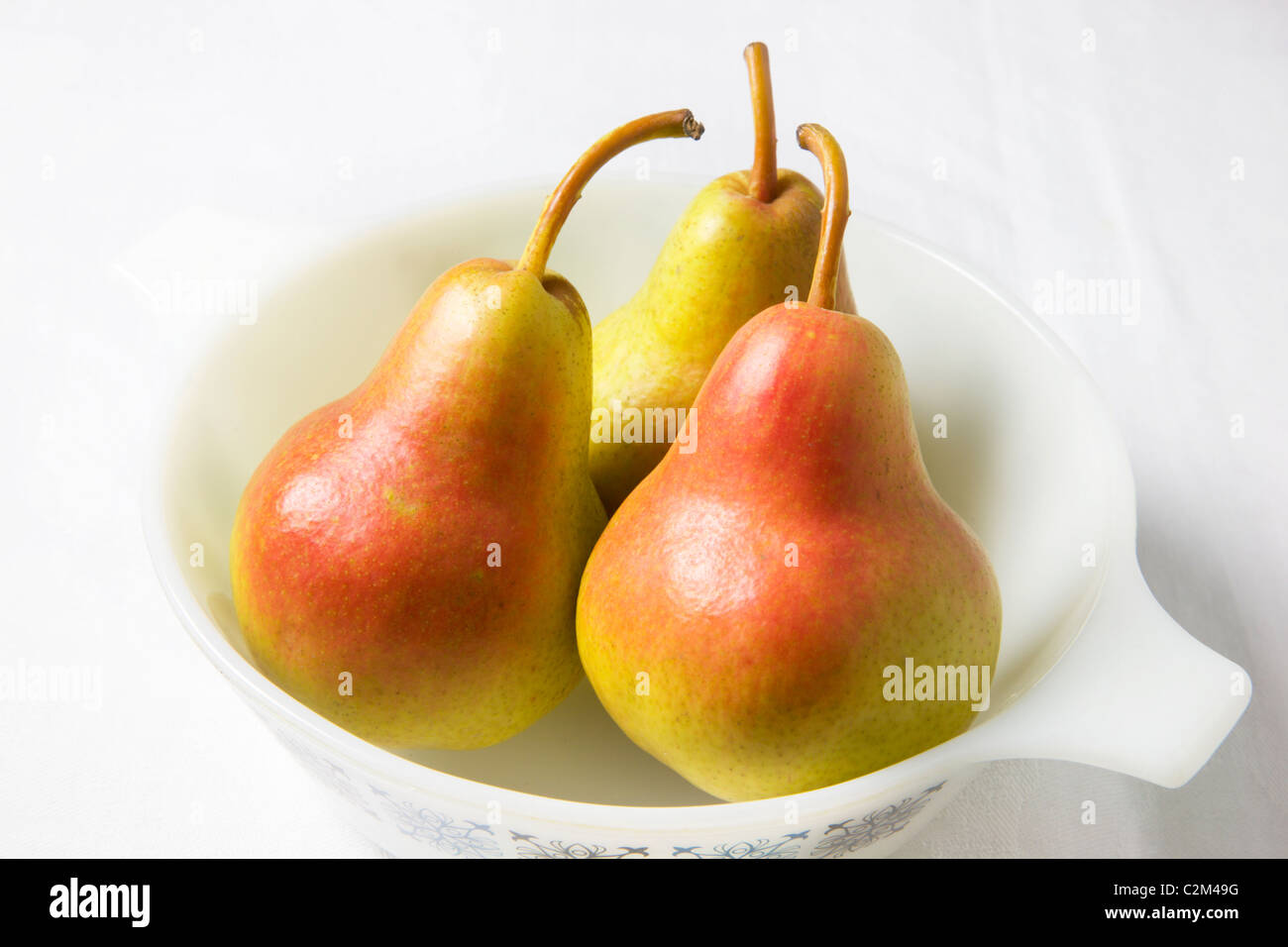 Three Blush Pears in a White Dish Stock Photo - Alamy