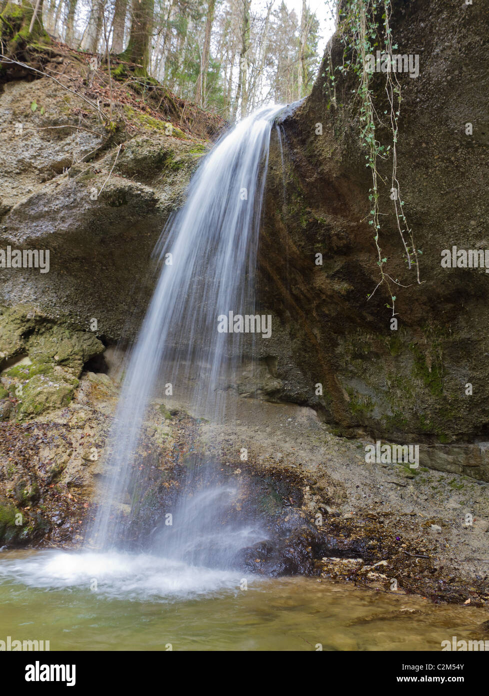 waterfall coming down over hollow cliff in the woods long exposure ...