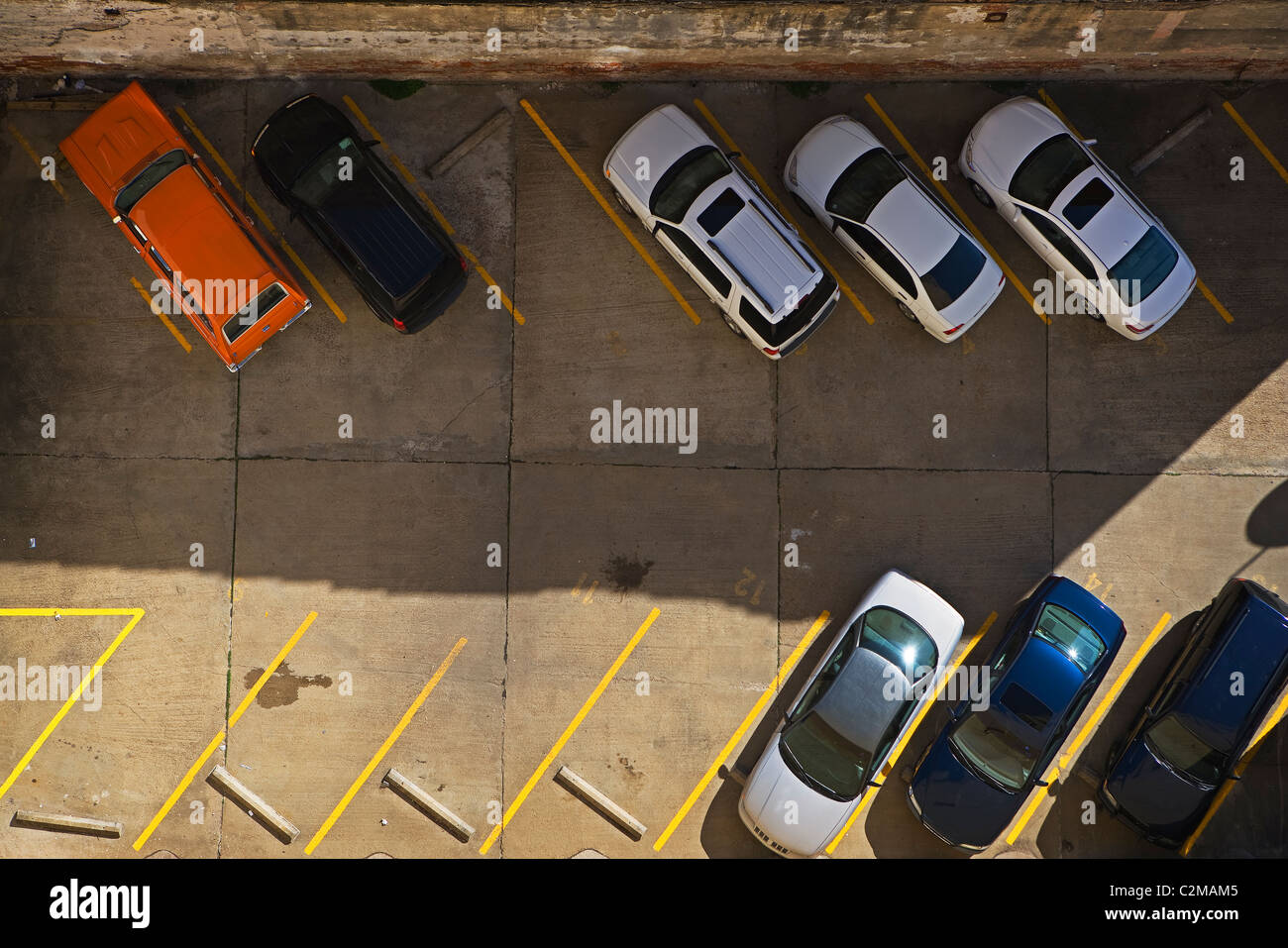 Parking lot in late afternoon sunlight with yellow stripes and colorful ...