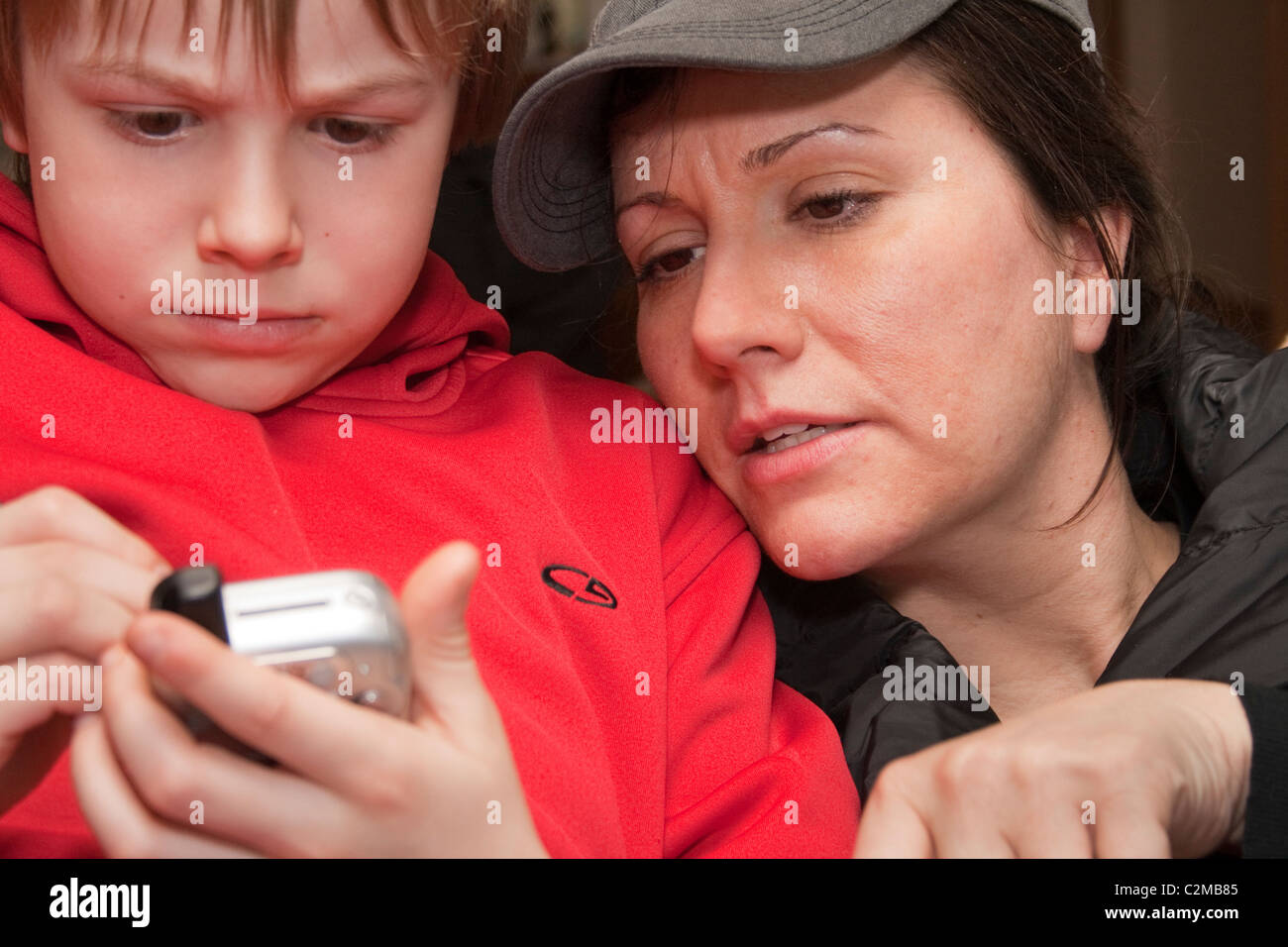 Mother and son age 39 and 8 playing a handheld computer video game ...