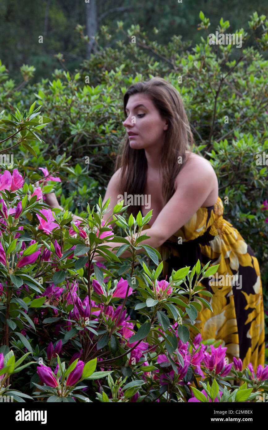 a pretty woman in yellow dress outside with purple flowers from an ...