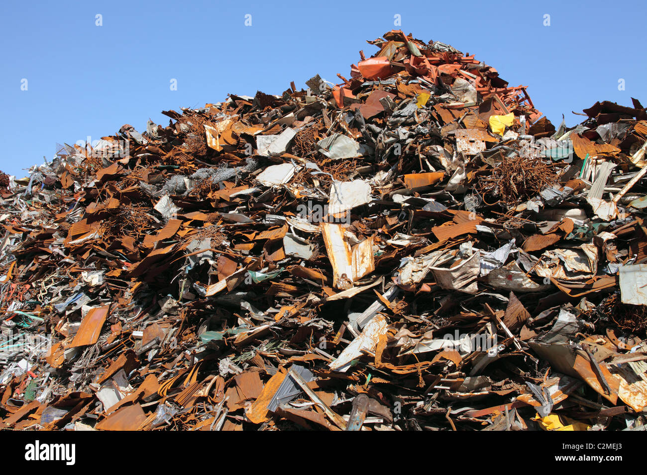 Stack of scrap metal against blue sky Stock Photo - Alamy