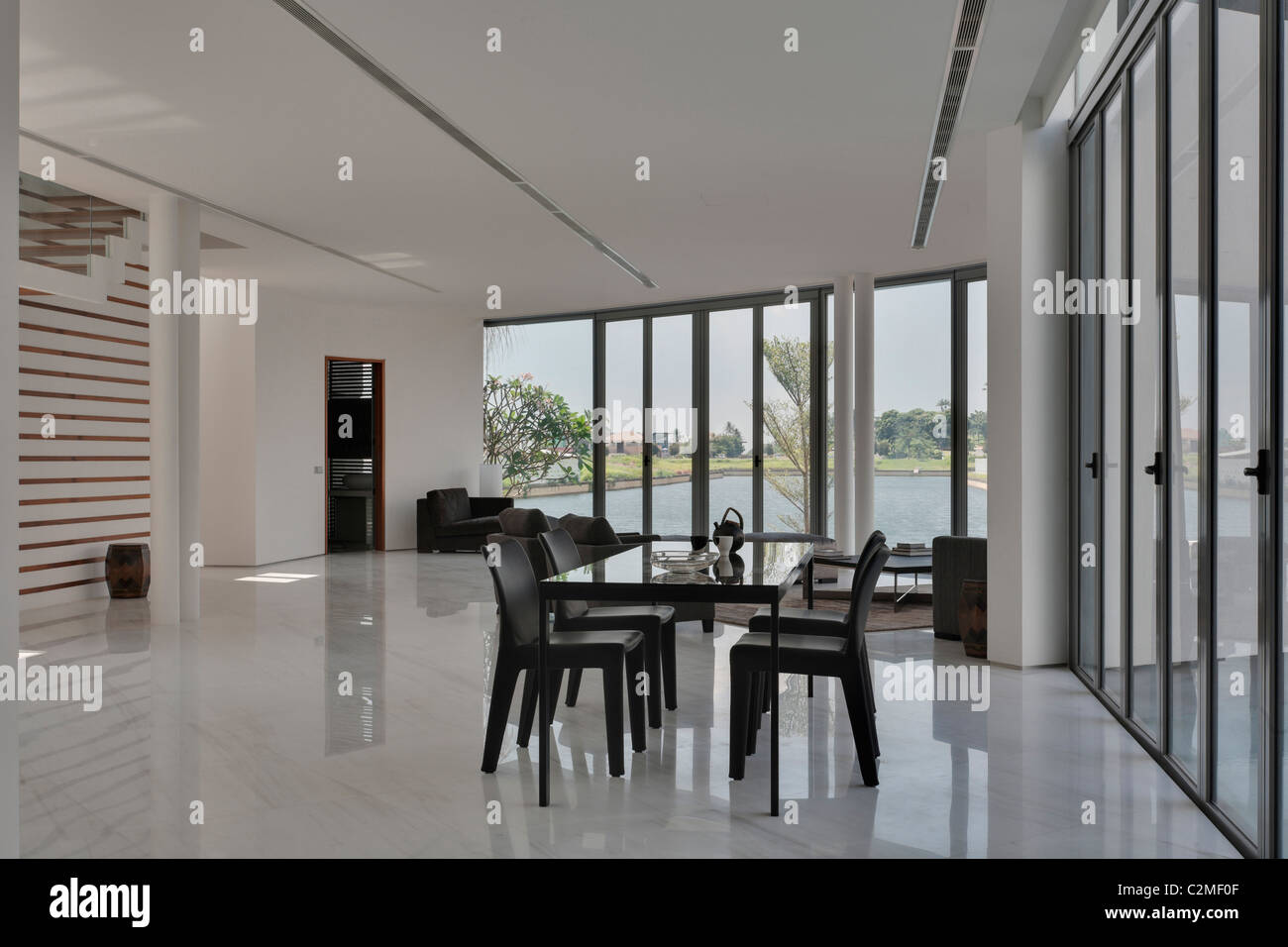 Modern house with white open-plan living area with full-height pivoting ...