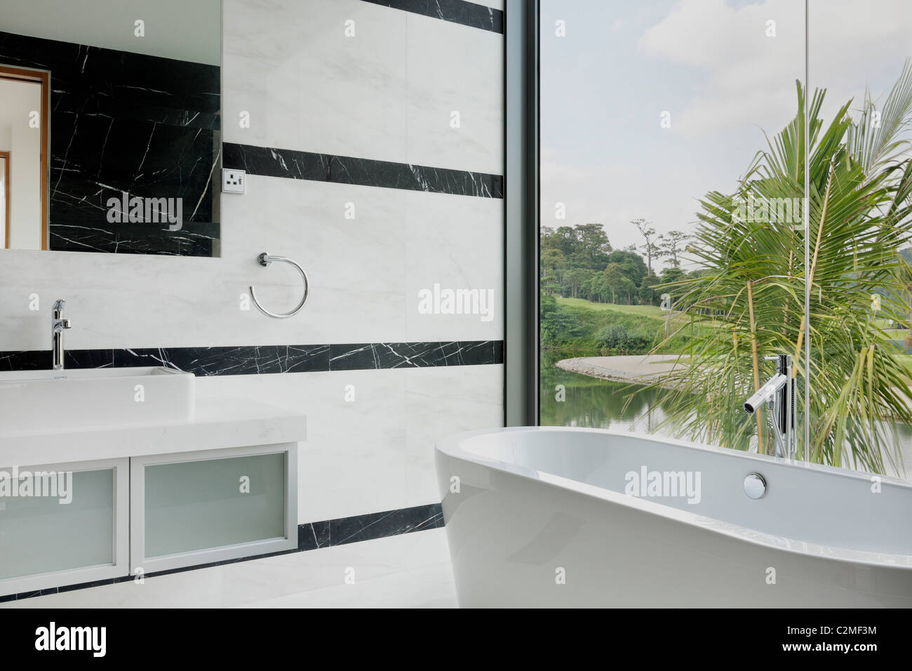 Marble and glass walls in modern bathroom with view to golf course ...