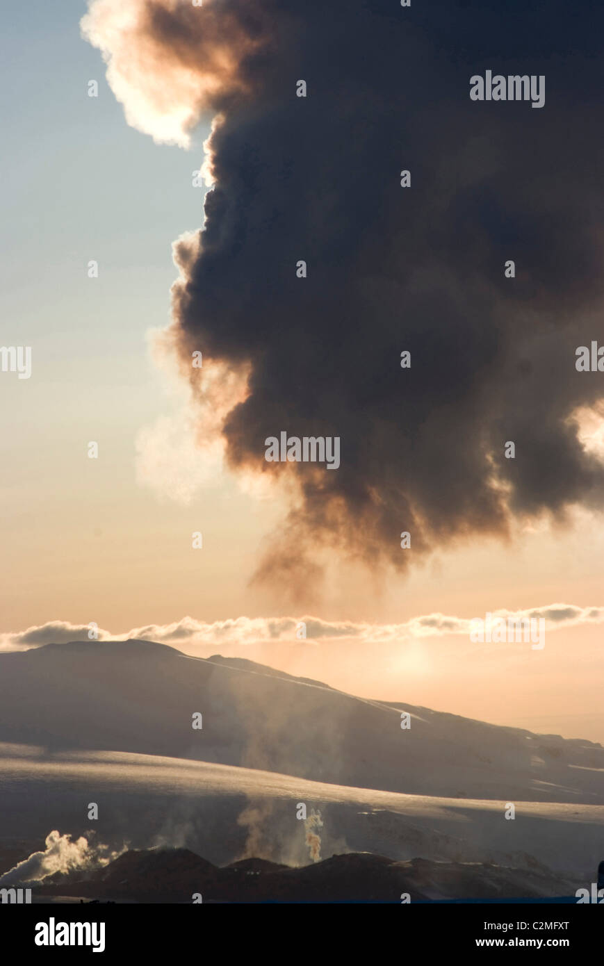 Plume of ash from Eyjafjallajokull volcano silhoeutted against sunset ...