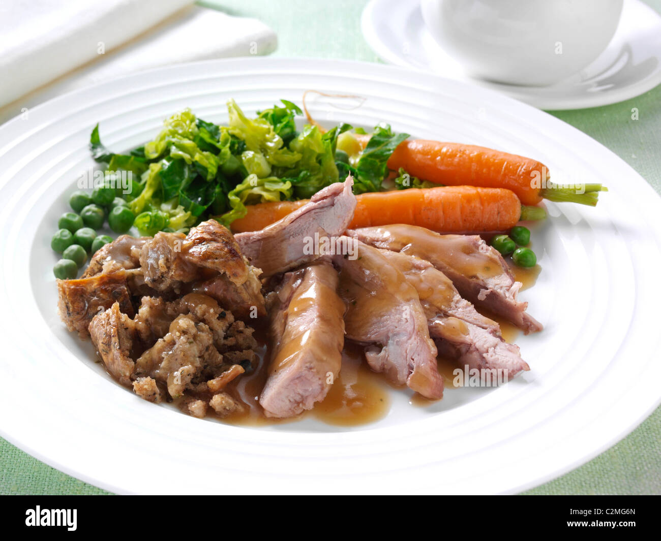Roast turkey thigh with stuffing carrots cabbage peas and gravy Stock ...