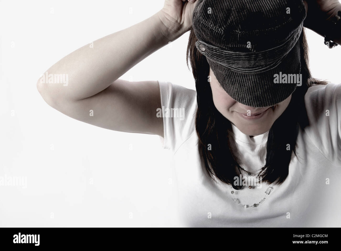 Woman Putting On A Hat Stock Photo - Alamy