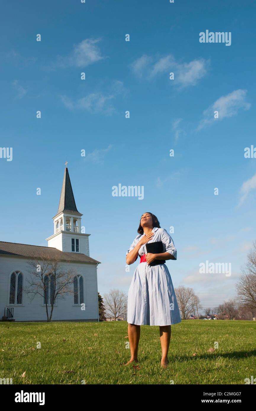 Woman Outside With Bible, Standing Near A Church, Praying Stock Photo ...