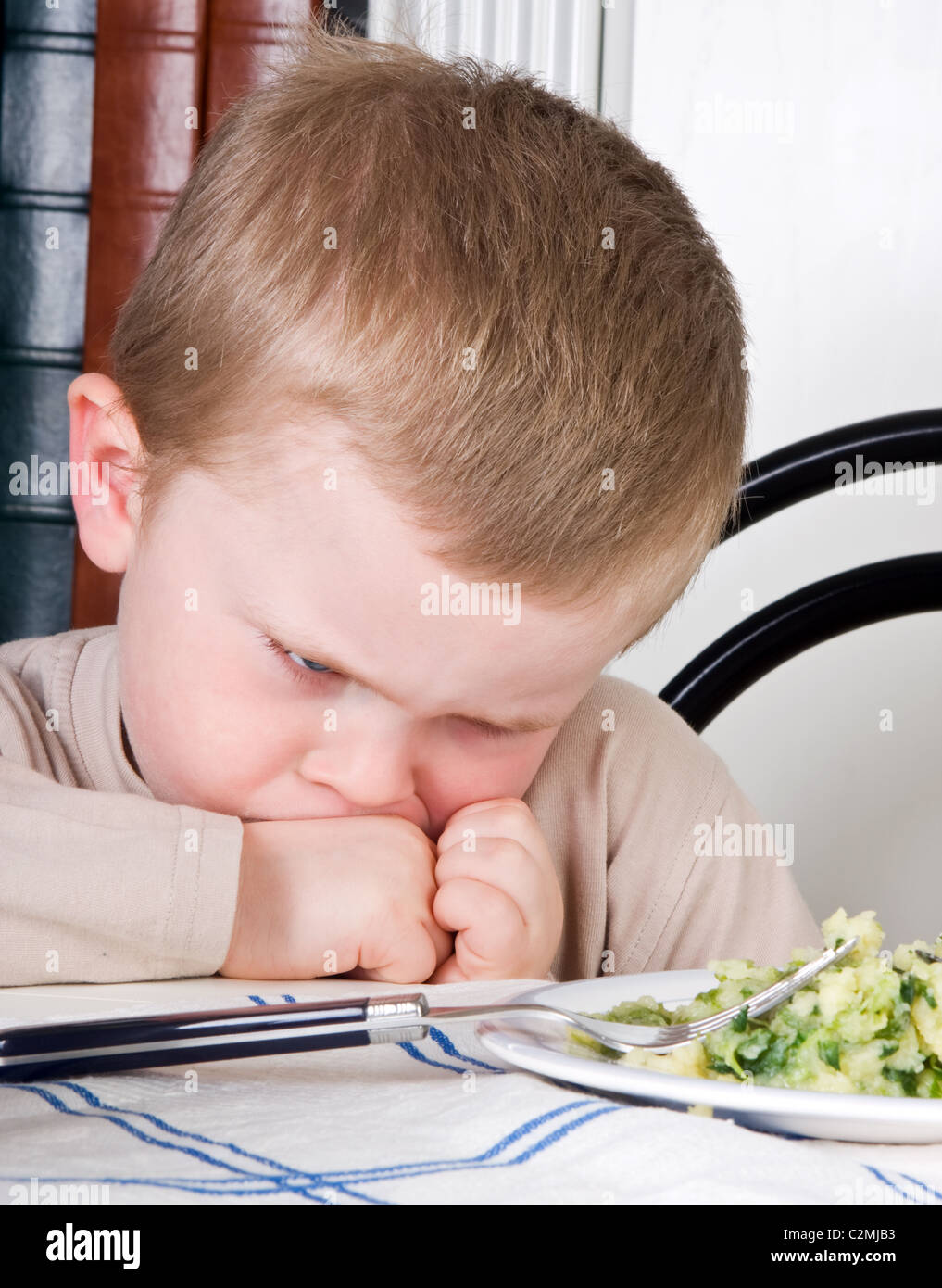 Four year old boy disliking the food on his plate Stock Photo - Alamy