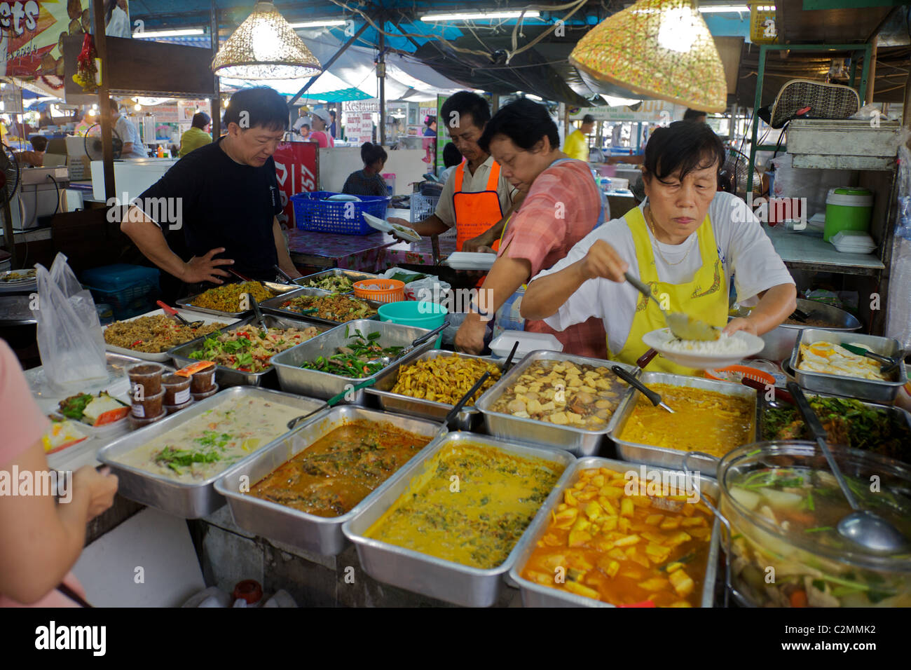 A Thai woman serving a Thai meal on a market stall, Phuket, Thailand ...