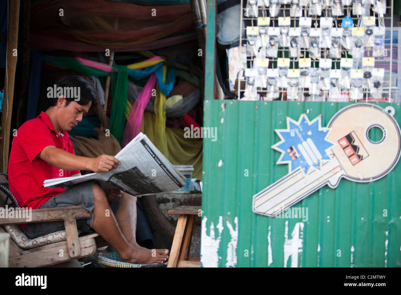 Street peddling key shopkeeper waiting customer while reading newspaper ...
