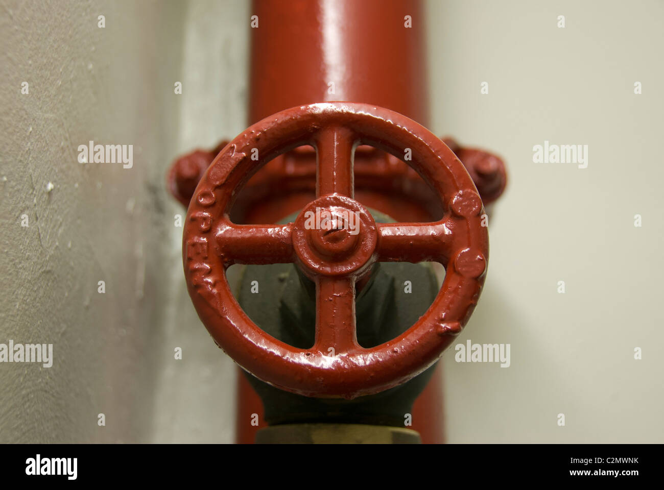 A red painted circular valve in anti-fire system pipes of a civil ...