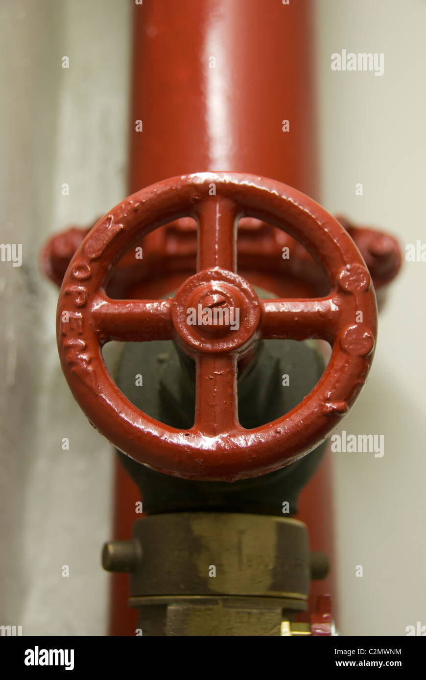 A red painted circular valve in anti-fire system pipes of a civil ...